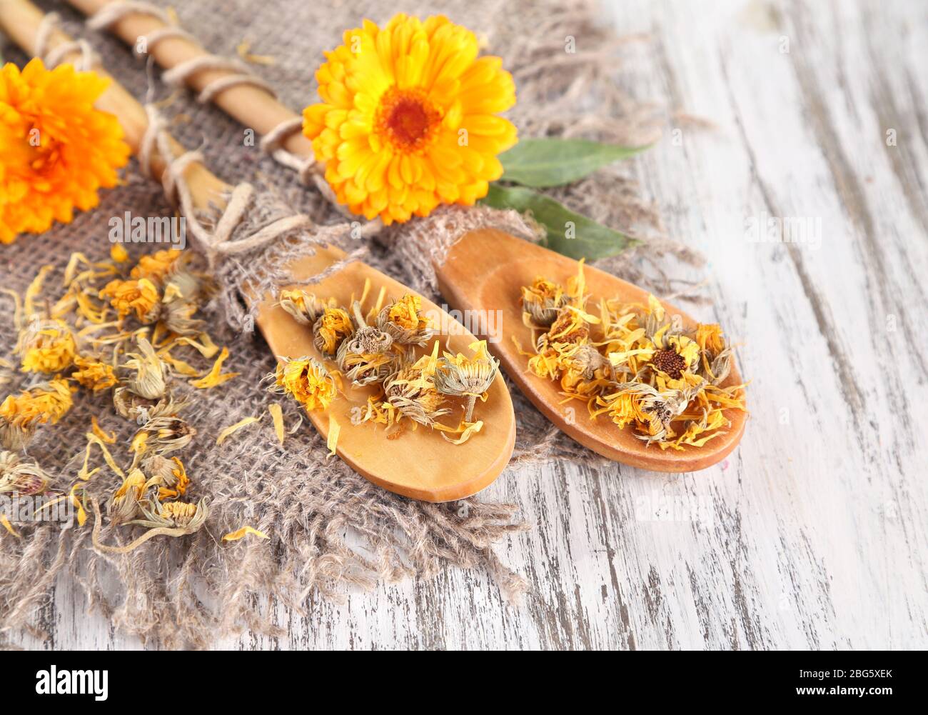 Fresh and dried calendula flowers on wooden background Stock Photo - Alamy
