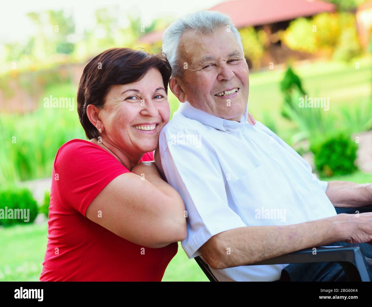 Portrait of happy old father and his 50 years daughter at nurising home ...