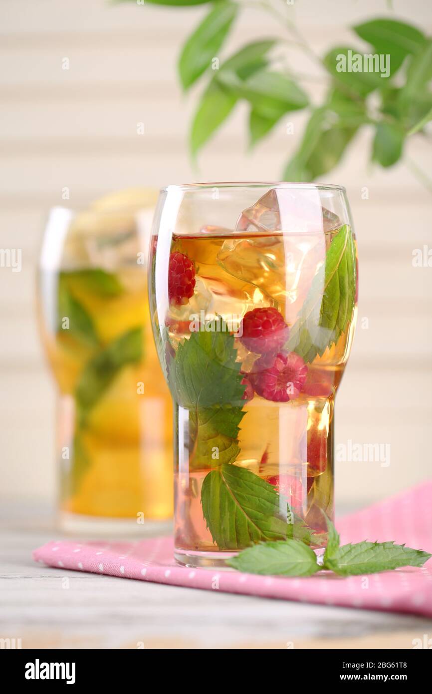 Iced tea with raspberries, lemon and mint on wooden table Stock Photo ...
