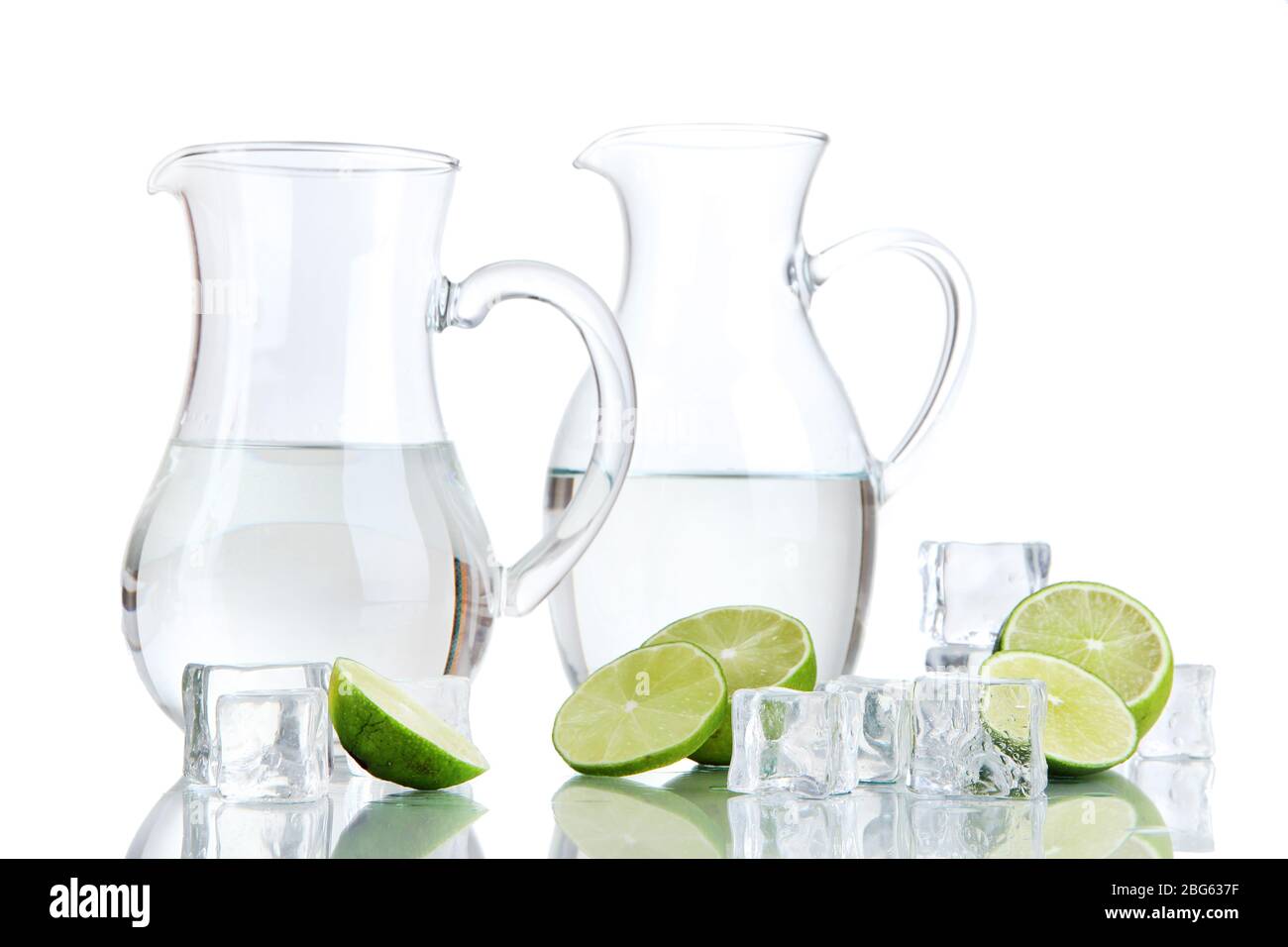 Glass pitchers of water with ice and lime isolated on white Stock Photo ...