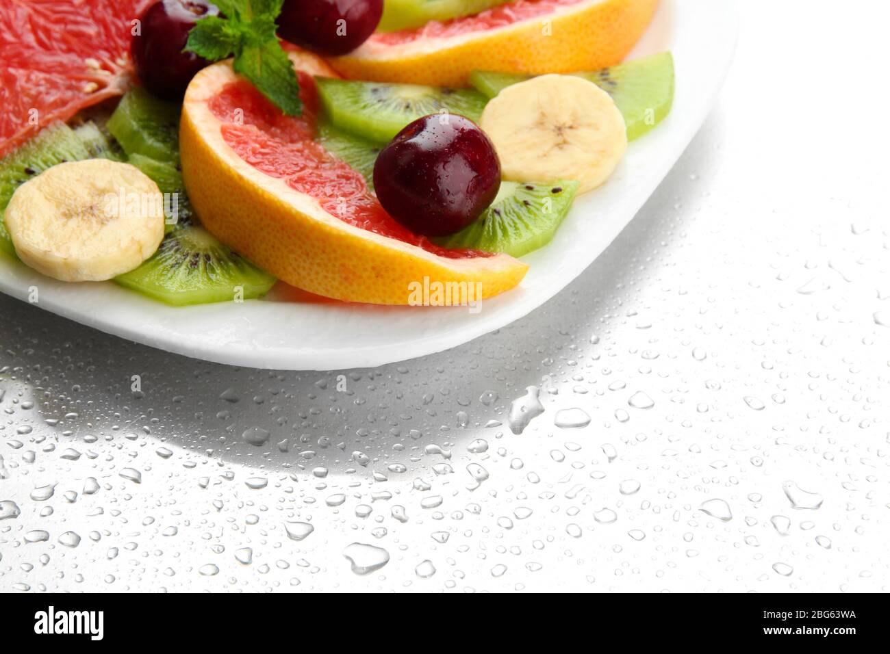 Assortment of sliced fruits on plate with drops Stock Photo - Alamy