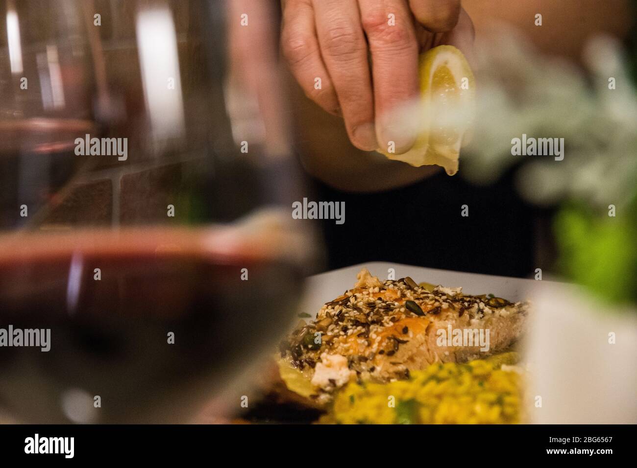 Dripping lemon juice on delicious breaded fish fillet at the restaurant ...