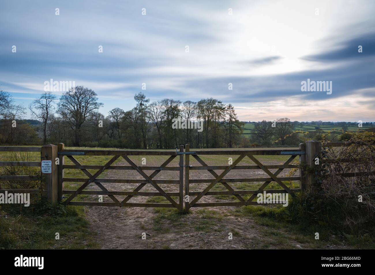 An old rustic wooden farm gate and a beautiful countryside landscape ...