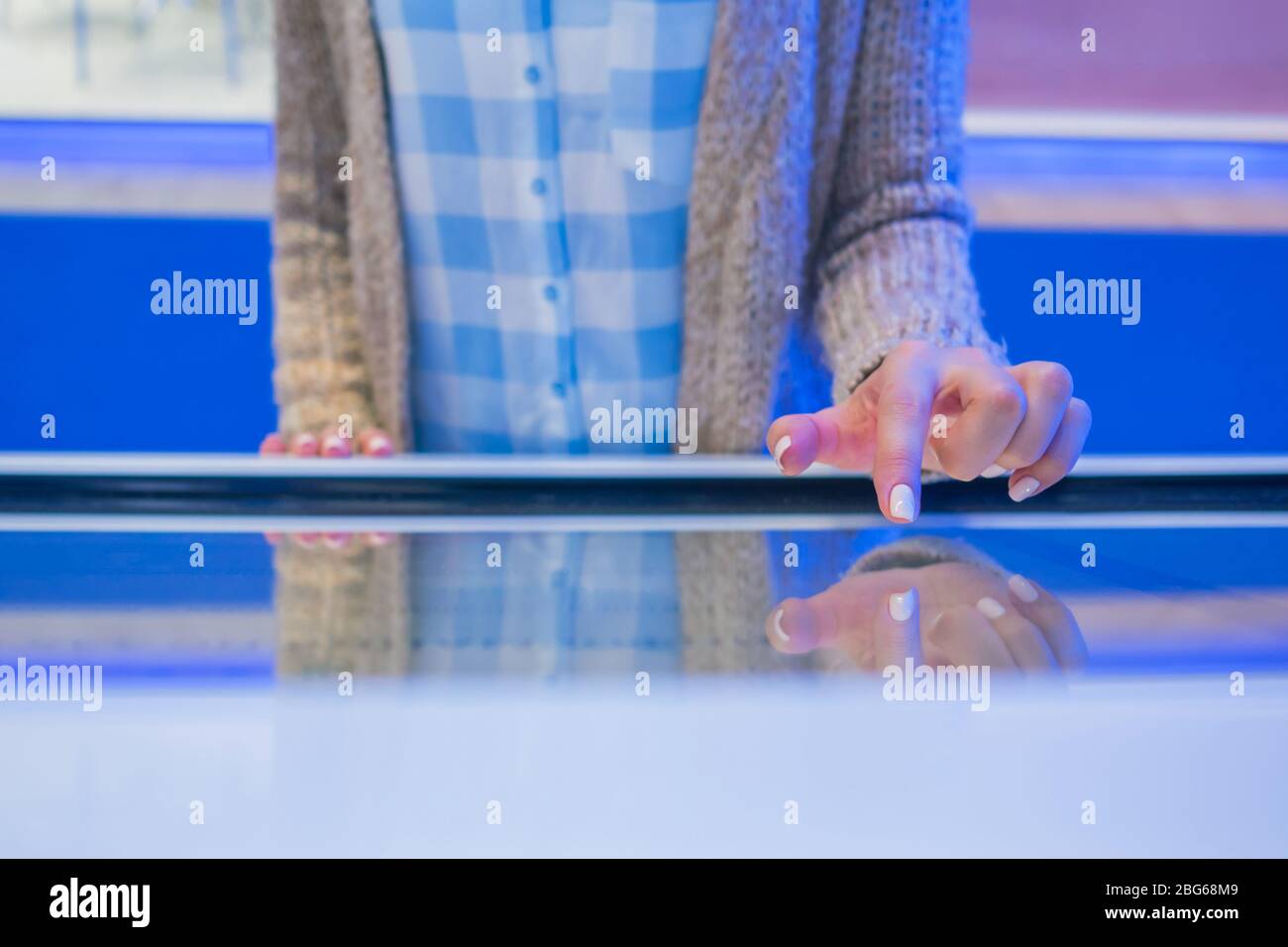 Woman using multimedia touchscreen display of interactive kiosk at ...