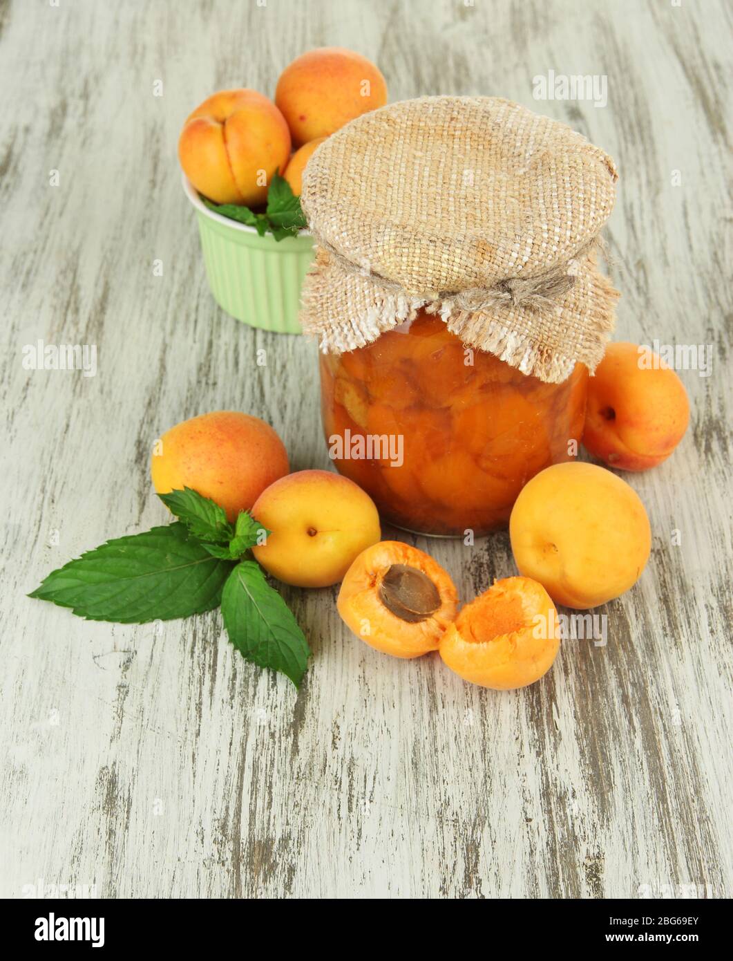 Apricot jam in glass jar and fresh apricots, on wooden background Stock ...