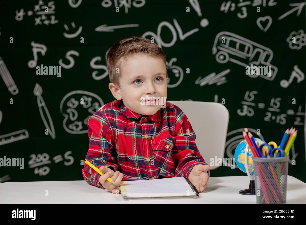 Cute child boy doing homework. Clever kid drawing at desk. Schoolboy ...