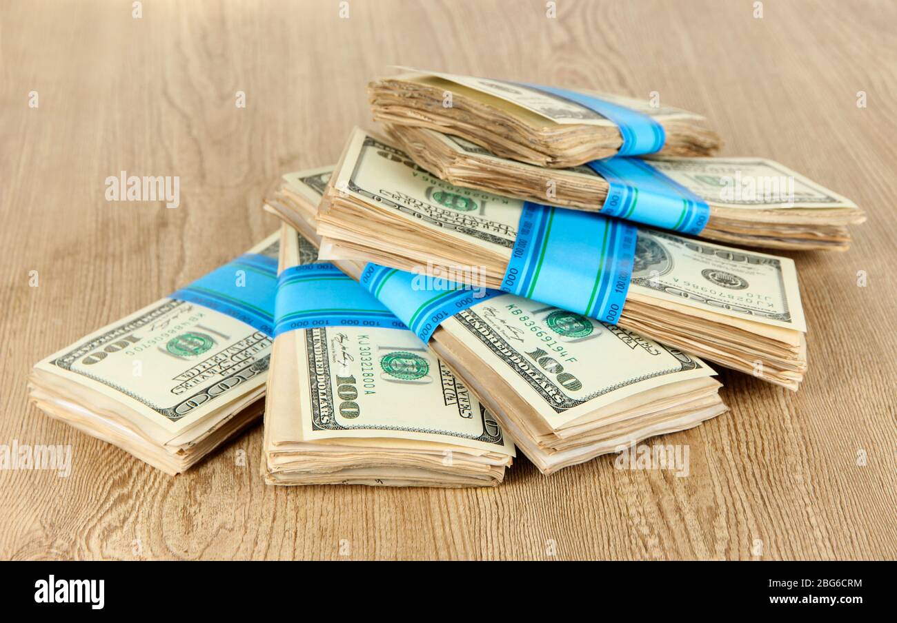 Stacks of money on wooden table Stock Photo - Alamy