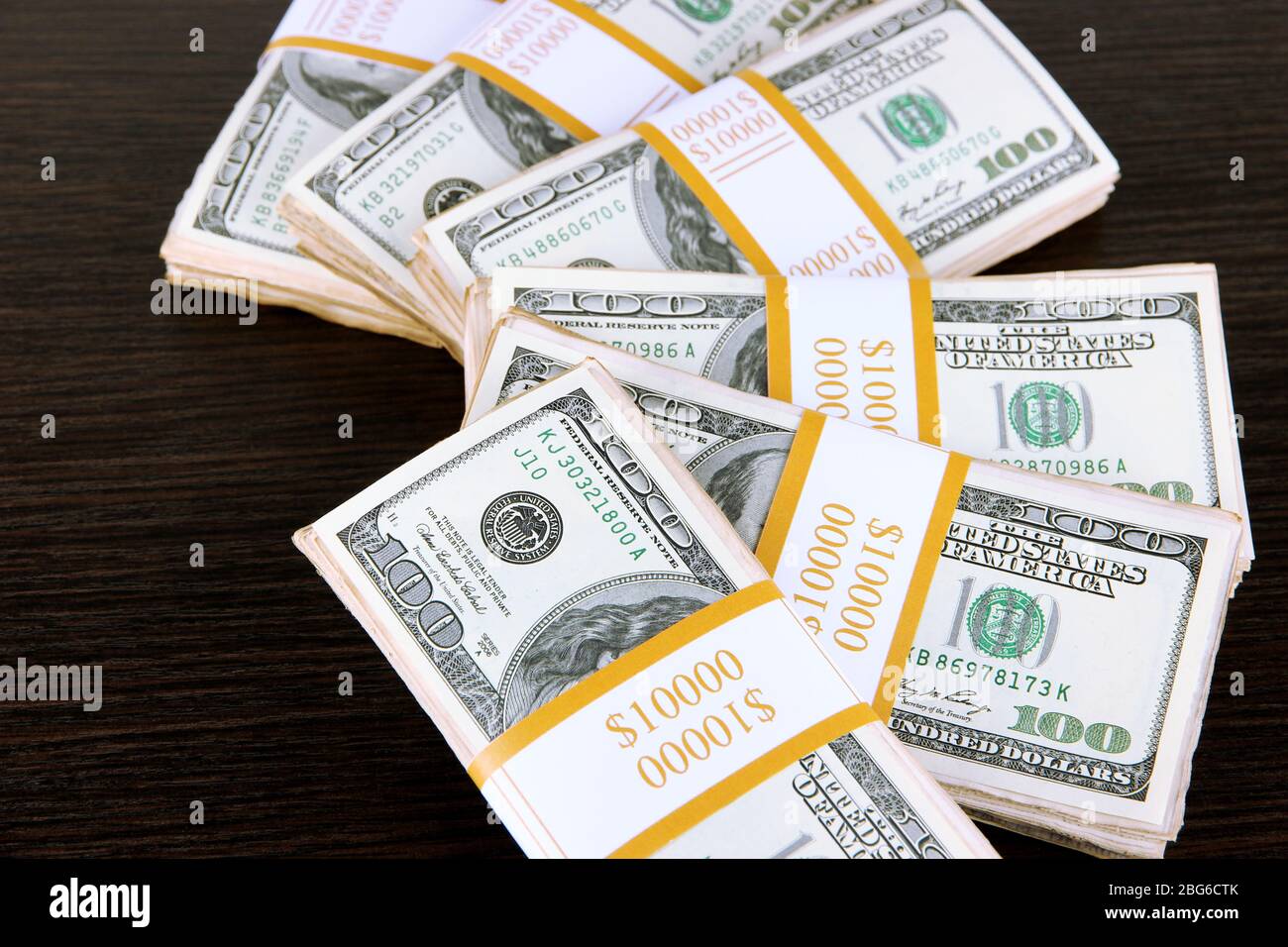 Stacks of money on wooden table Stock Photo - Alamy