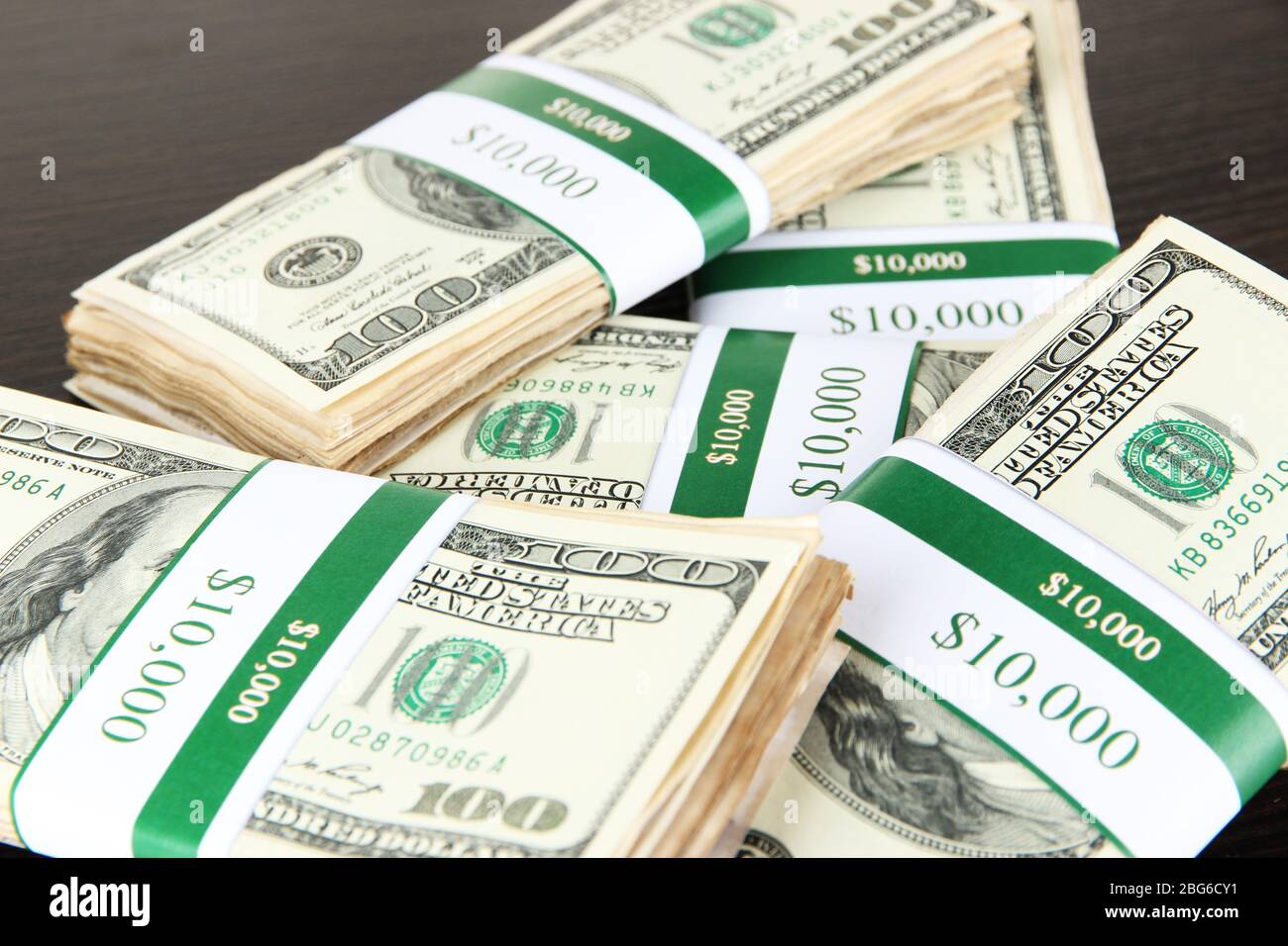 Stacks of money on wooden table Stock Photo - Alamy