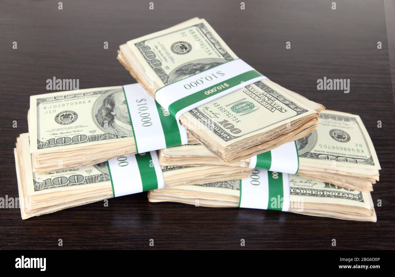 Stacks of money on wooden table Stock Photo - Alamy