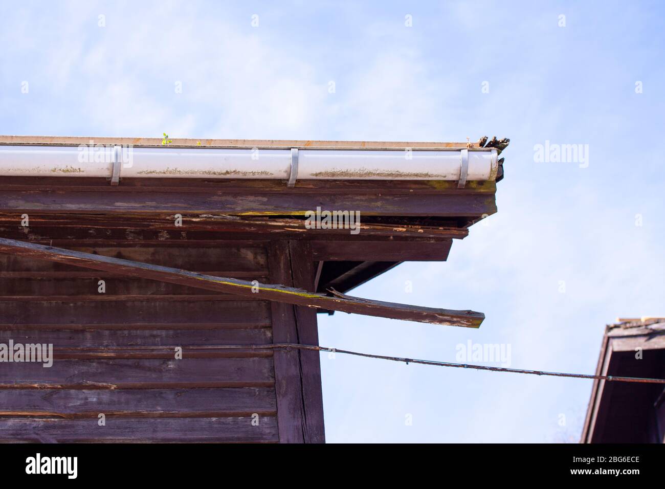 Rotten wood on top of old wooden building. Timber board falling off ...