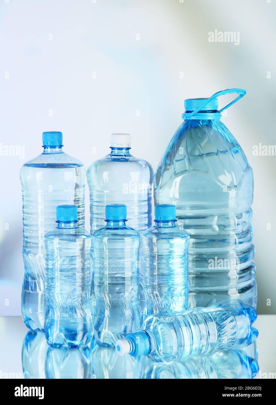 Water in different bottles on light background Stock Photo - Alamy