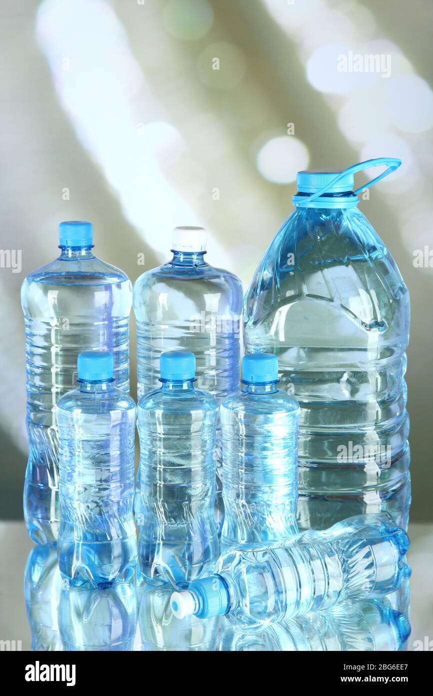 Water in different bottles on light background Stock Photo - Alamy