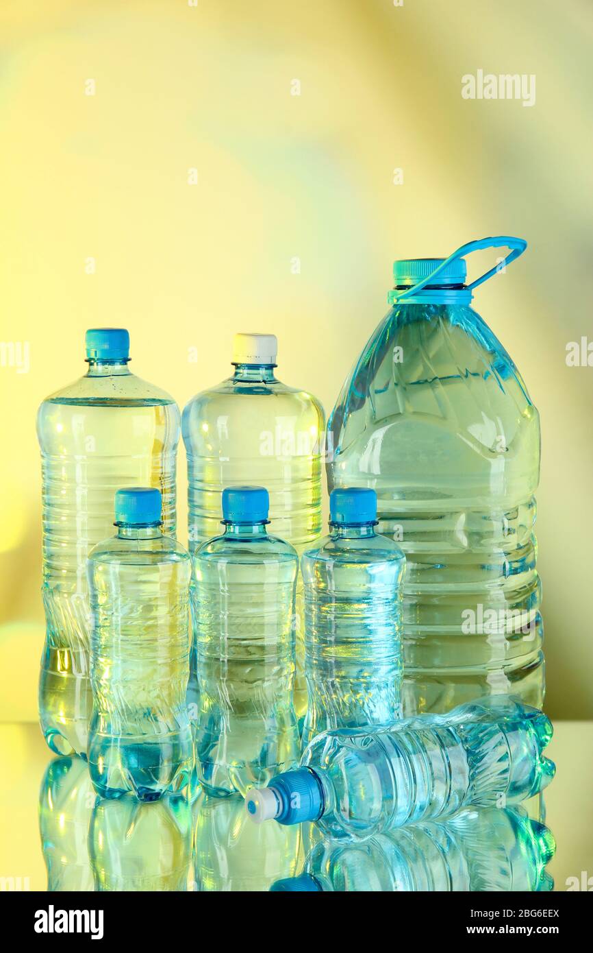 Water in different bottles on light background Stock Photo - Alamy