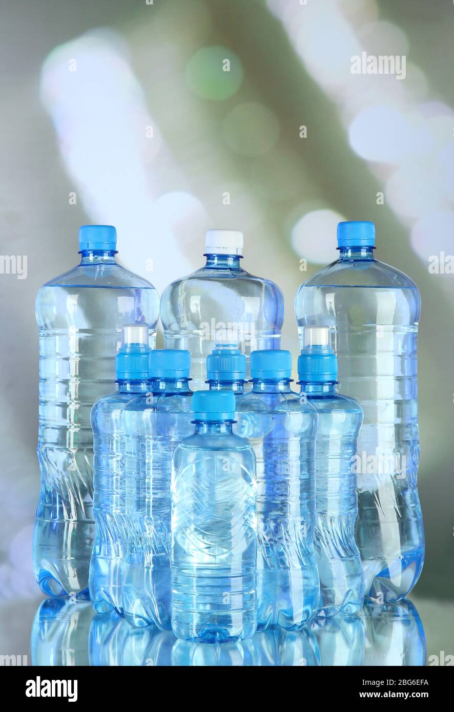 Water in different bottles on light background Stock Photo - Alamy