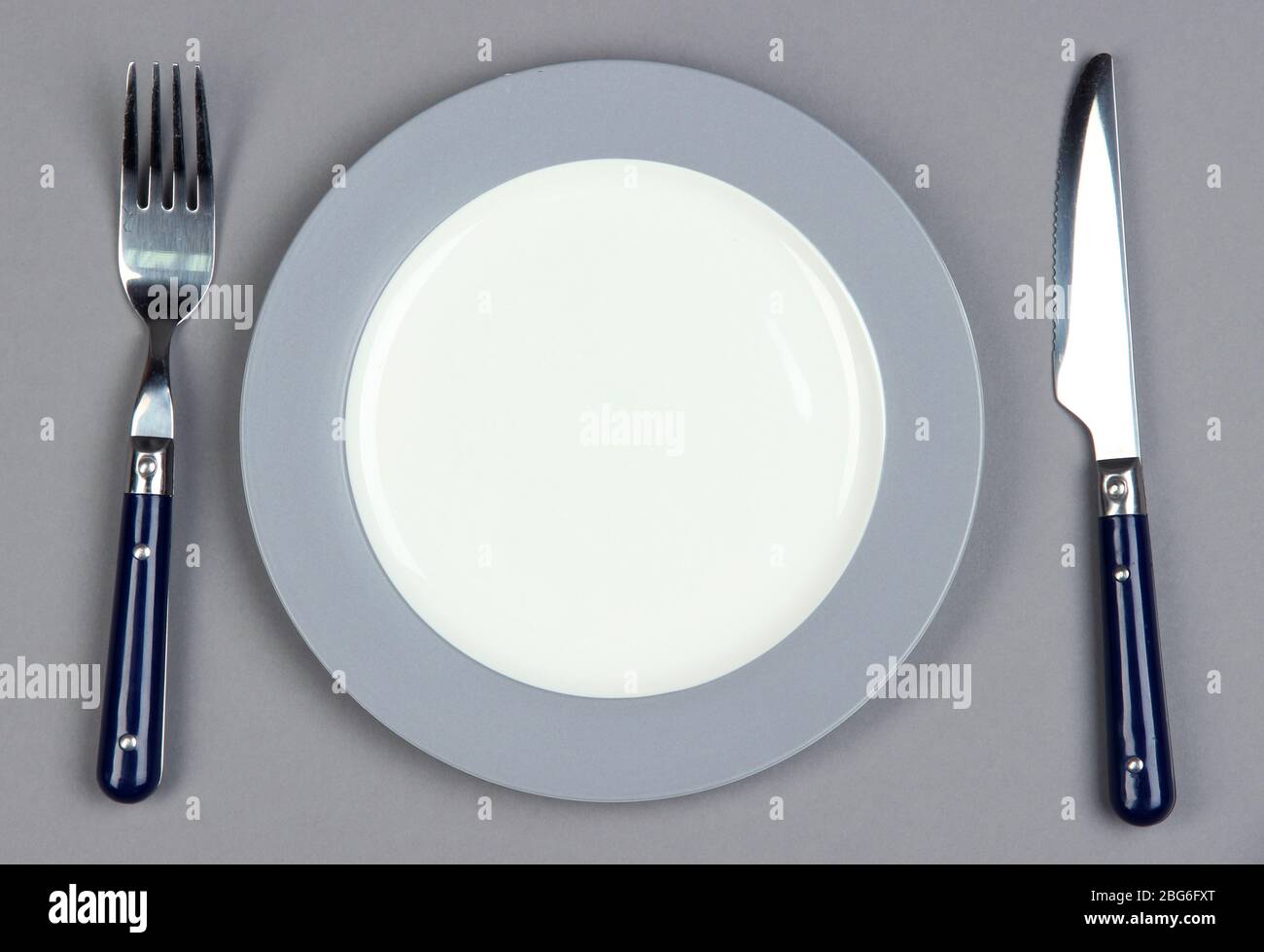 Knife, color plate and fork, on color background Stock Photo - Alamy