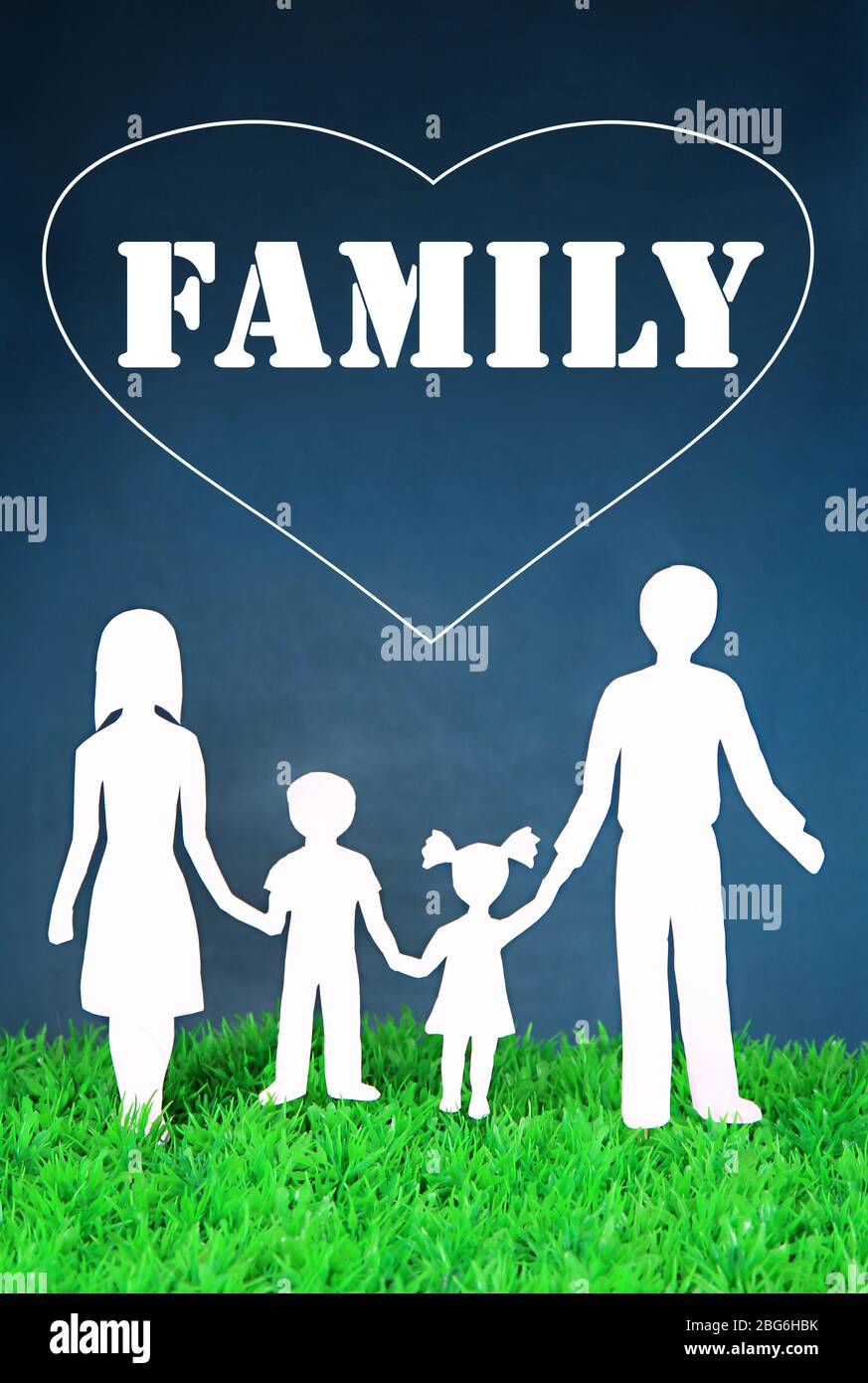 Family from paper on grass on bright background Stock Photo - Alamy