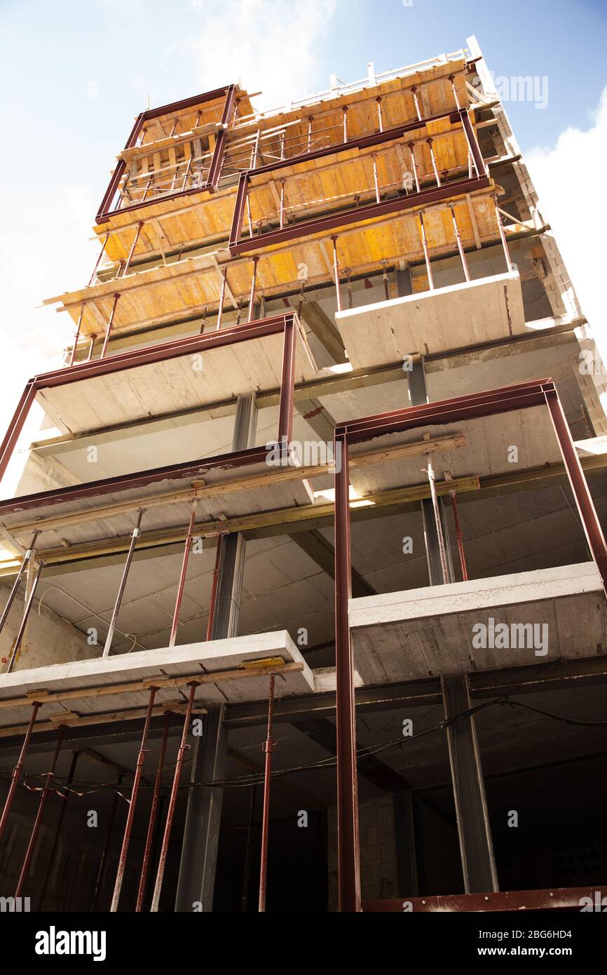 looking up at the open side of a building being build without its walls ...