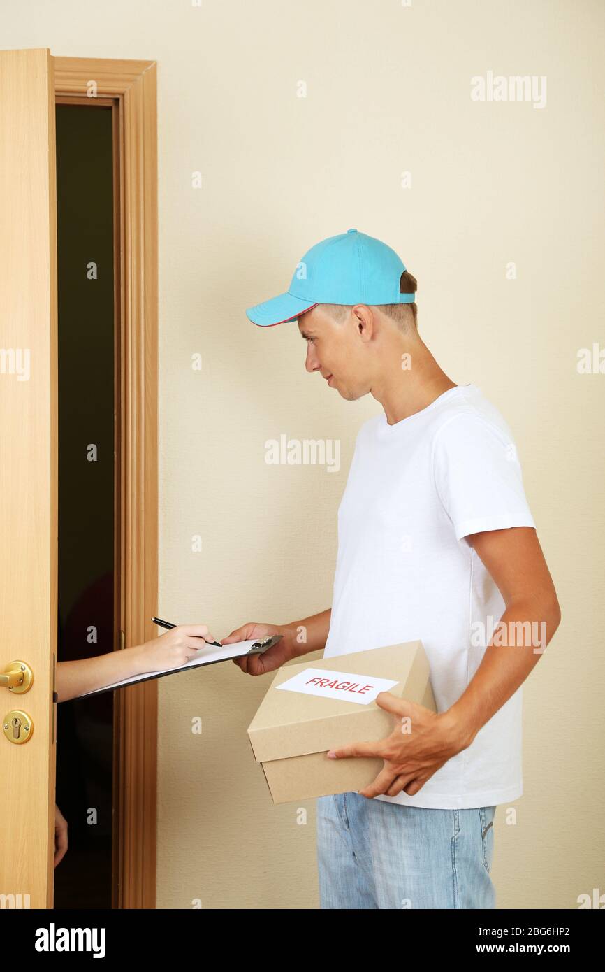Young delivery man giving parcel Stock Photo - Alamy