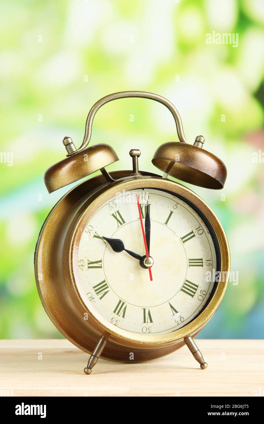 Old alarm clock on bright background Stock Photo - Alamy