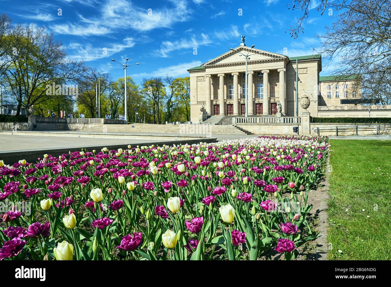 a flowerbed with colorful flowers in front of the historic opera house ...