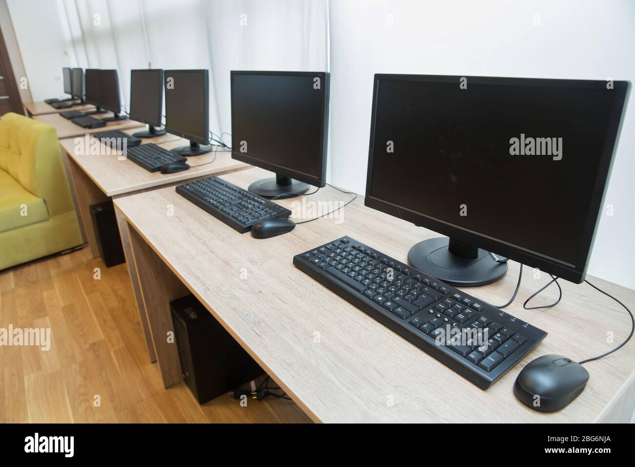 two computers and a desk . Keyboard and mouse . Two computer monitors with a black screen on a ...