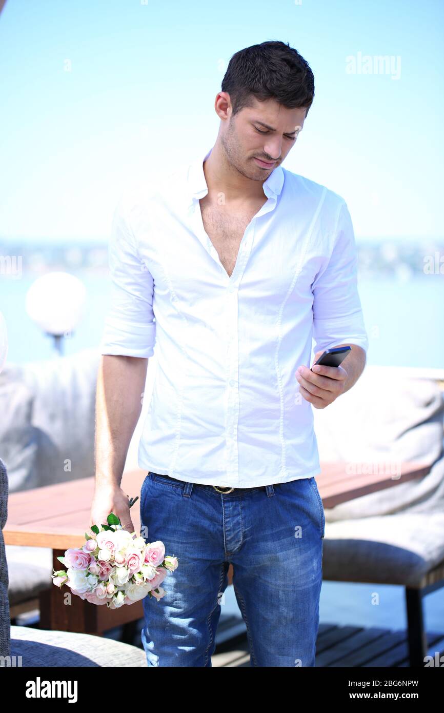 Handsome with bouquet of roses man waiting a woman Stock Photo - Alamy