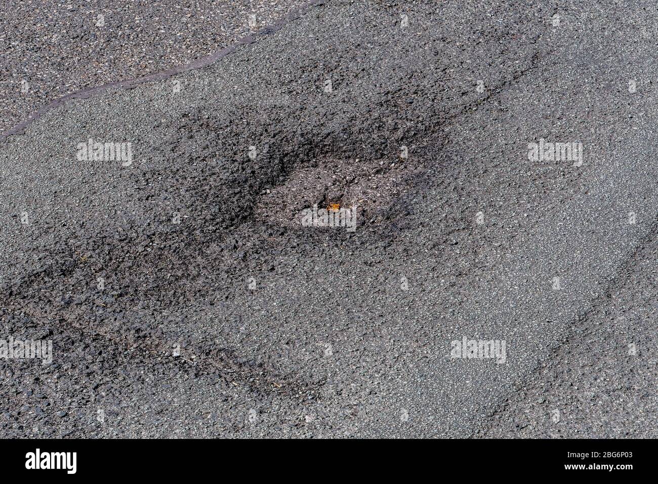Small pothole which has developed in a road Stock Photo - Alamy
