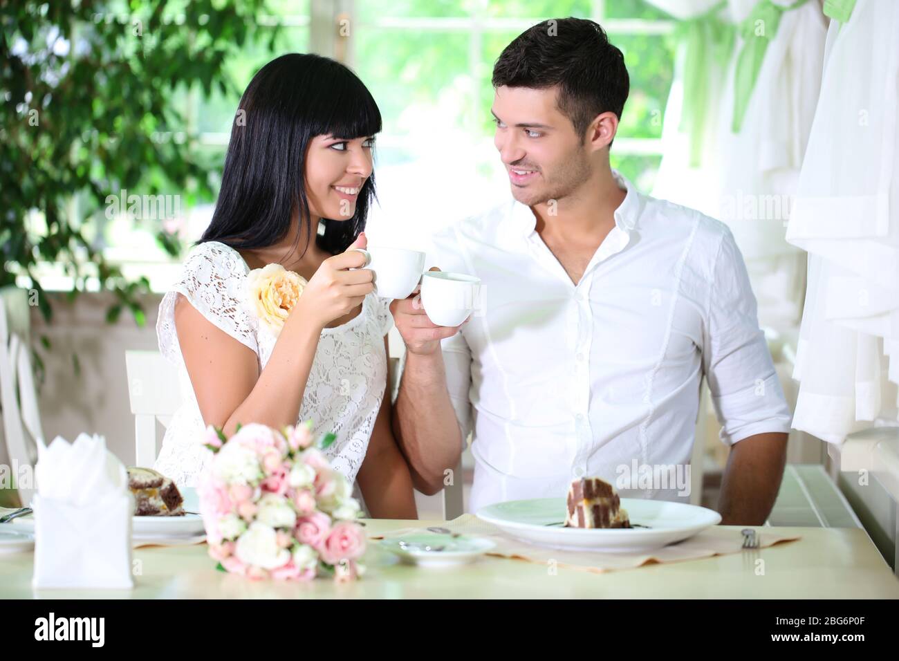 Beautiful young romantic couple at cafe Stock Photo - Alamy