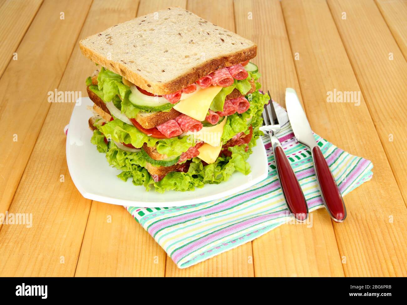 Huge sandwich on wooden table, on bright background Stock Photo - Alamy