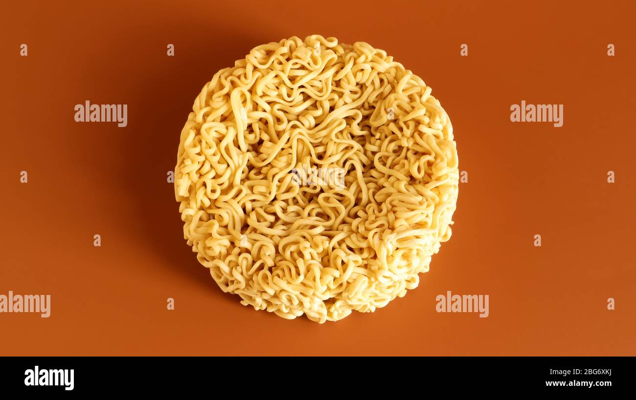 Korean instant noodles in the shape of a circle on a brown background ...