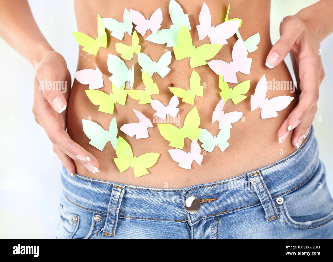 Butterfly on stomach on light background Stock Photo - Alamy