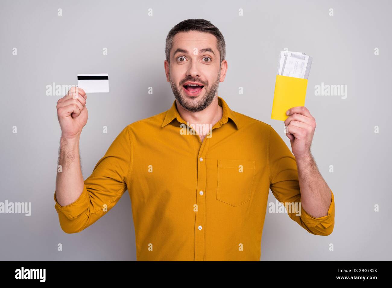 Portrait of surprised crazy mature man hold tickets vise credit card ...