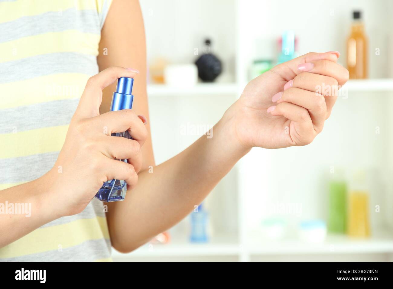 Woman testing perfume on shop windows background Stock Photo - Alamy