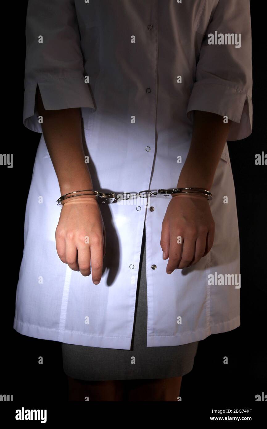 Doctor in handcuffs on dark background Stock Photo - Alamy
