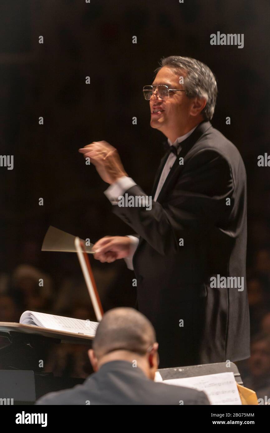 Conductor (model released) directs classical orchestra in performance ...