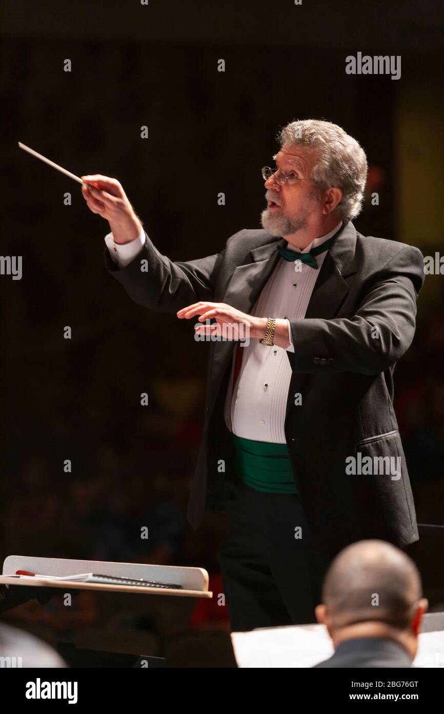 Conductor (model released) directs classical orchestra in performance ...