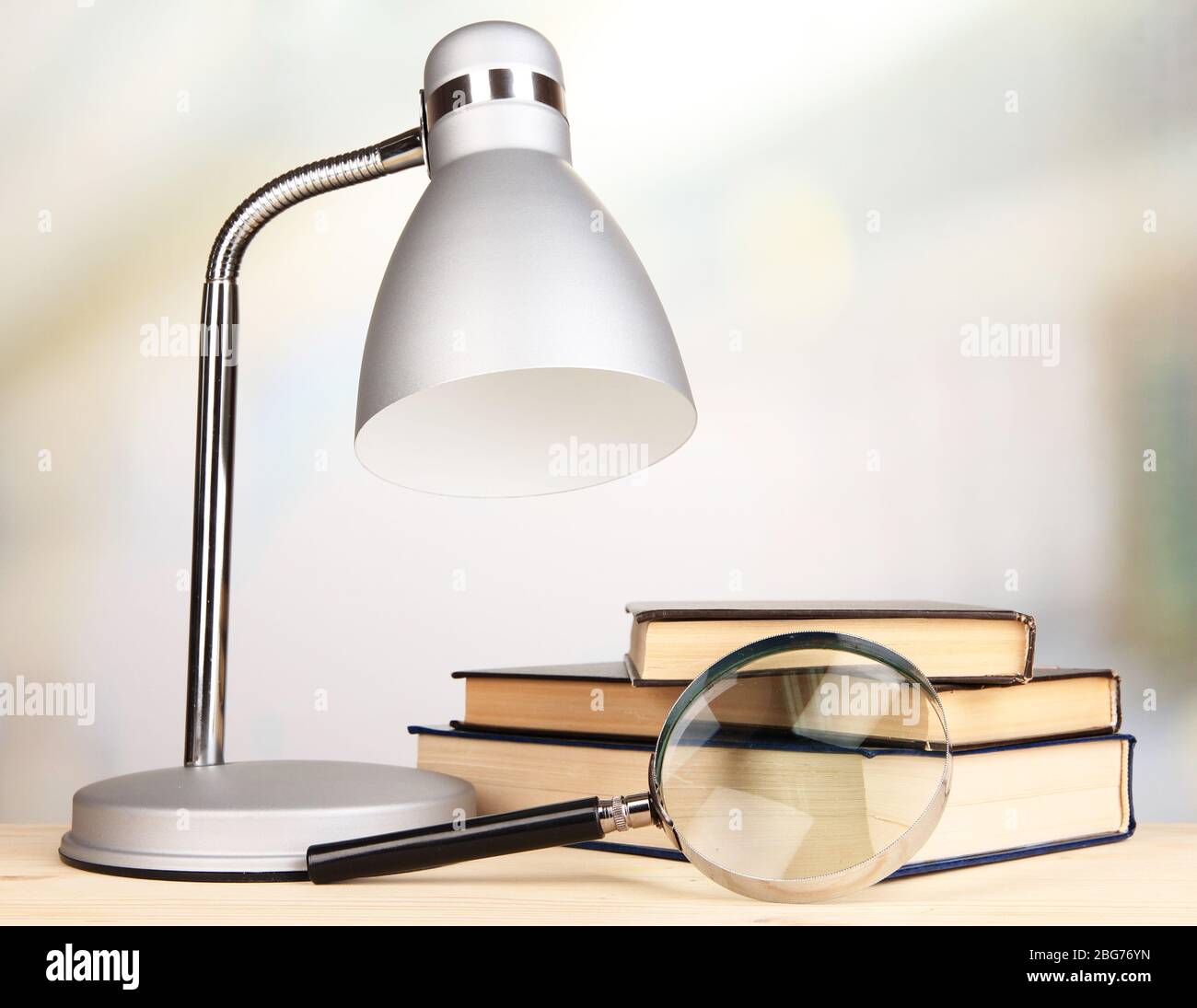 Table lamp and books on desk in room Stock Photo - Alamy