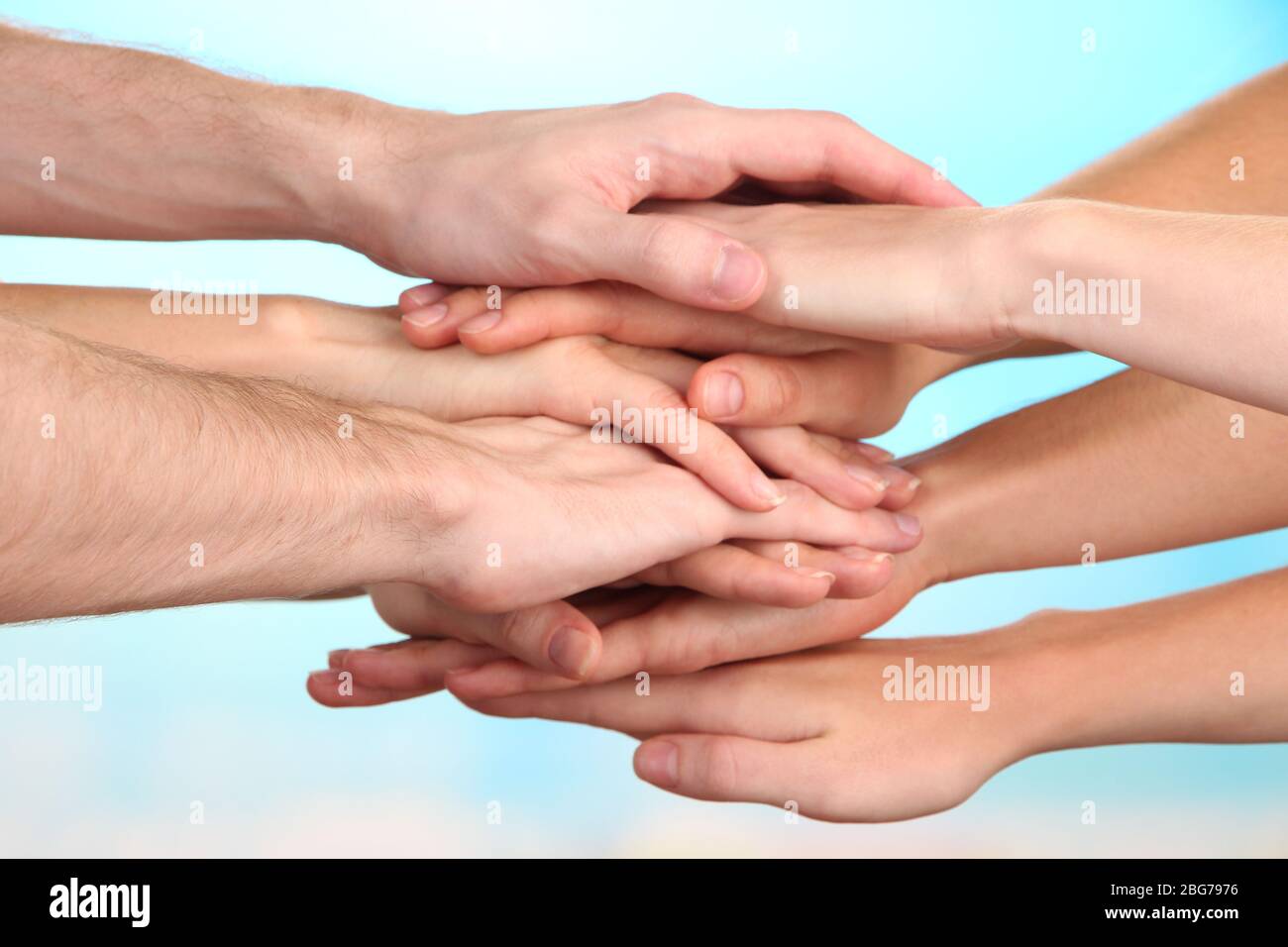 United hands on bright background. Conceptual photo of teamwork Stock ...