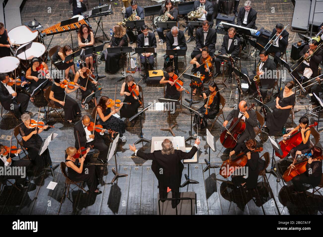 Overhead view of conductor leading orchestra (all model released) in ...