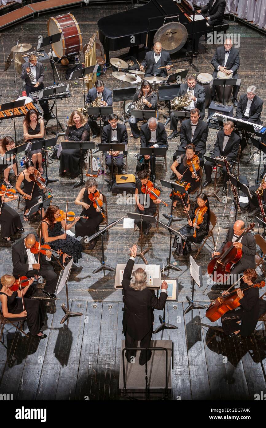 Overhead view of conductor leading orchestra (all model released) in ...