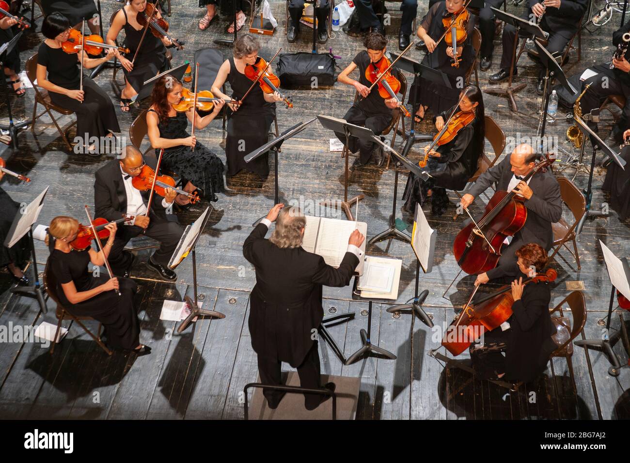 Overhead high angle view of conductor leading classical orchestra (all ...