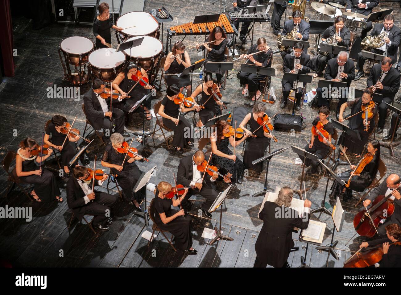 Overhead high angle view of conductor leading classical orchestra (all ...