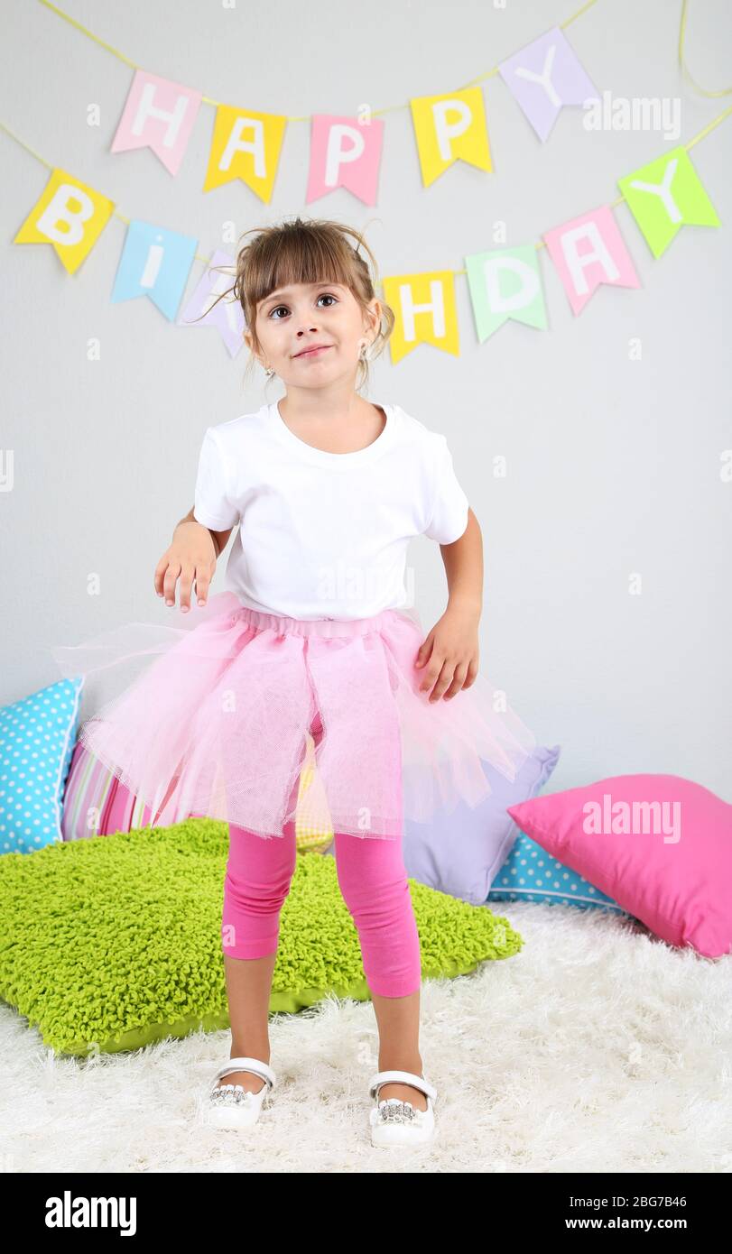 Little girl dancing on bed in room on grey wall background Stock Photo ...