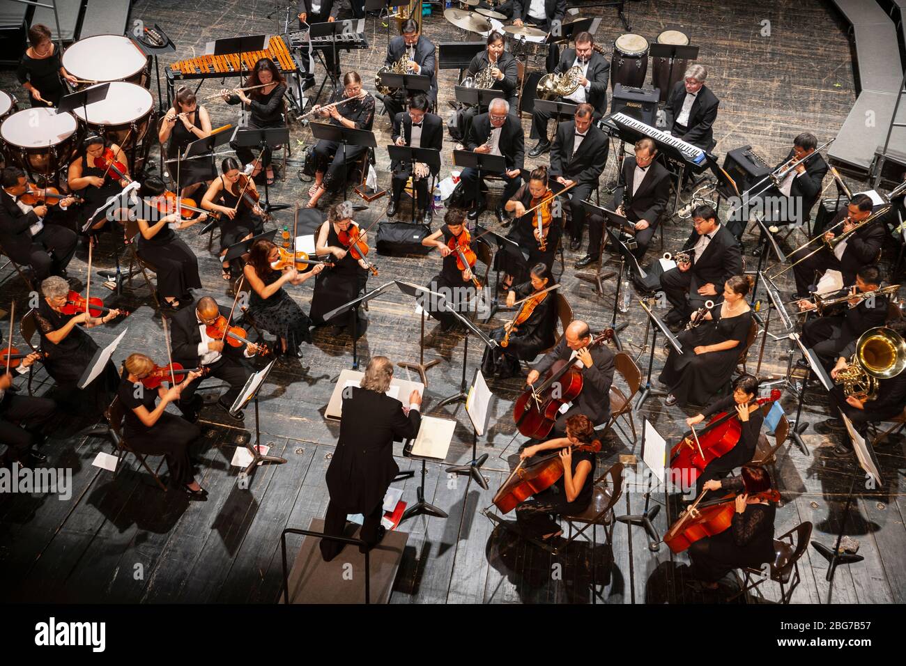 Overhead high angle view of conductor leading classical orchestra (all ...