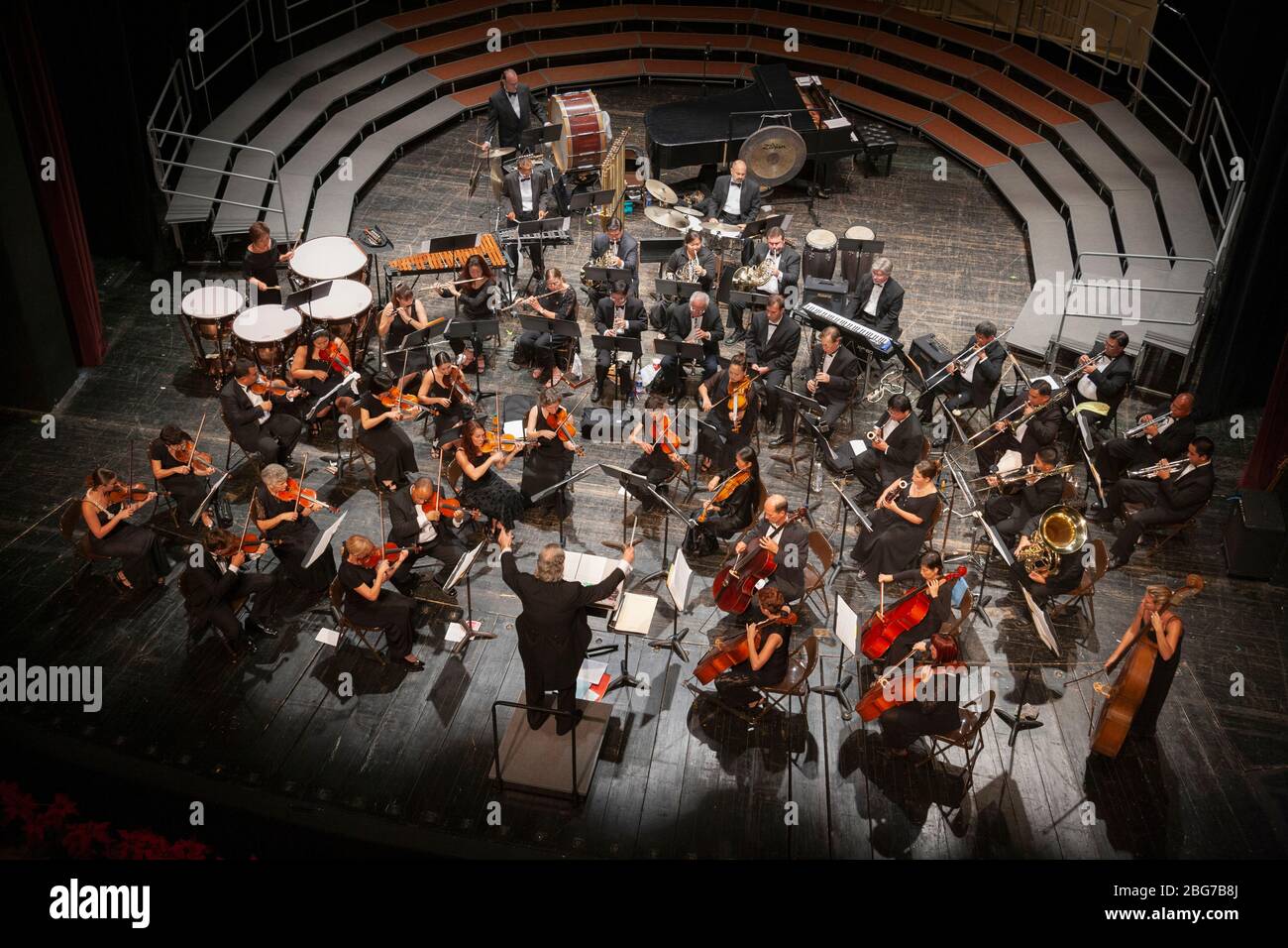 Overhead high angle view of conductor leading classical orchestra (all ...