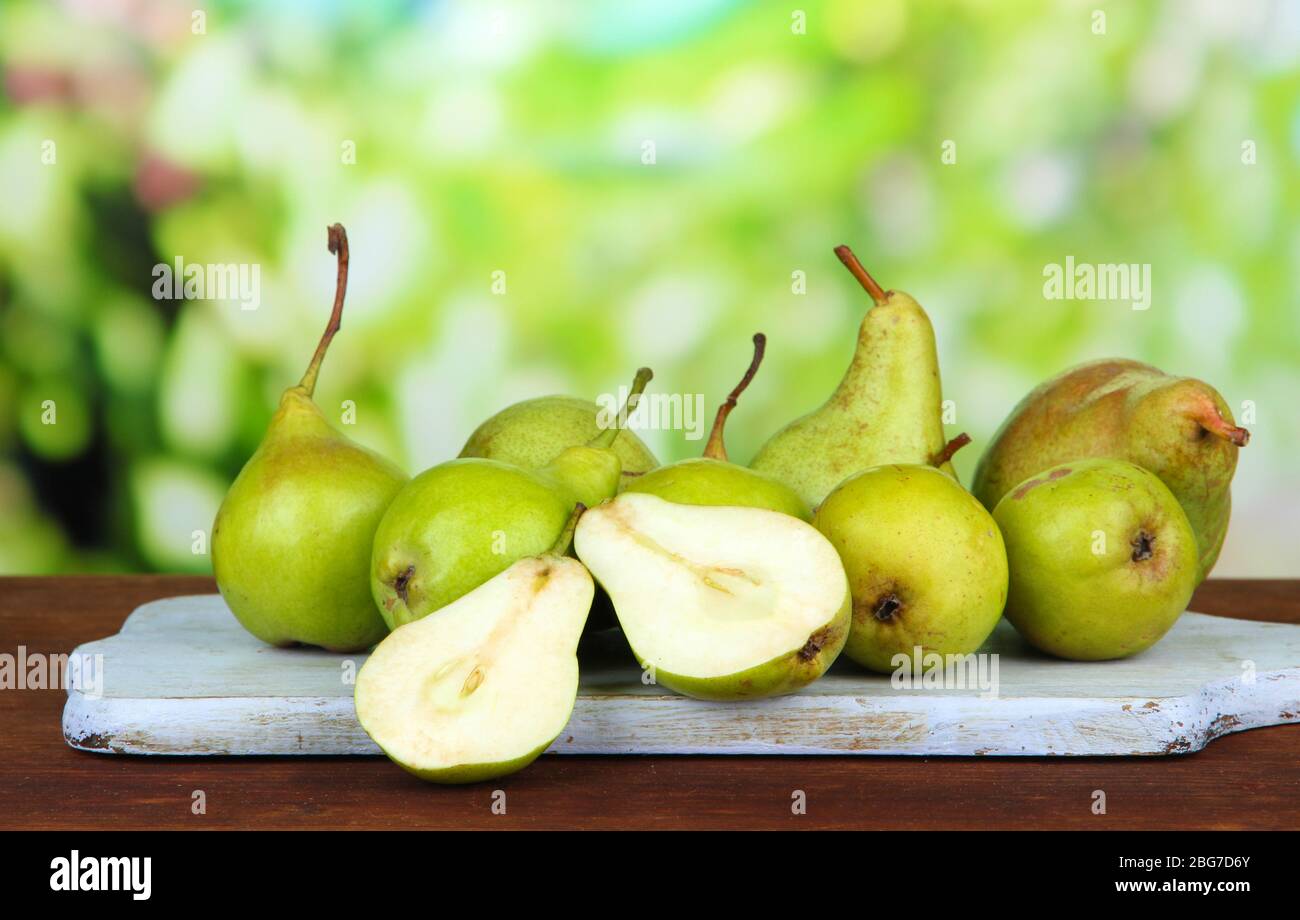 Pears on wooden cutting board, on bright background Stock Photo - Alamy