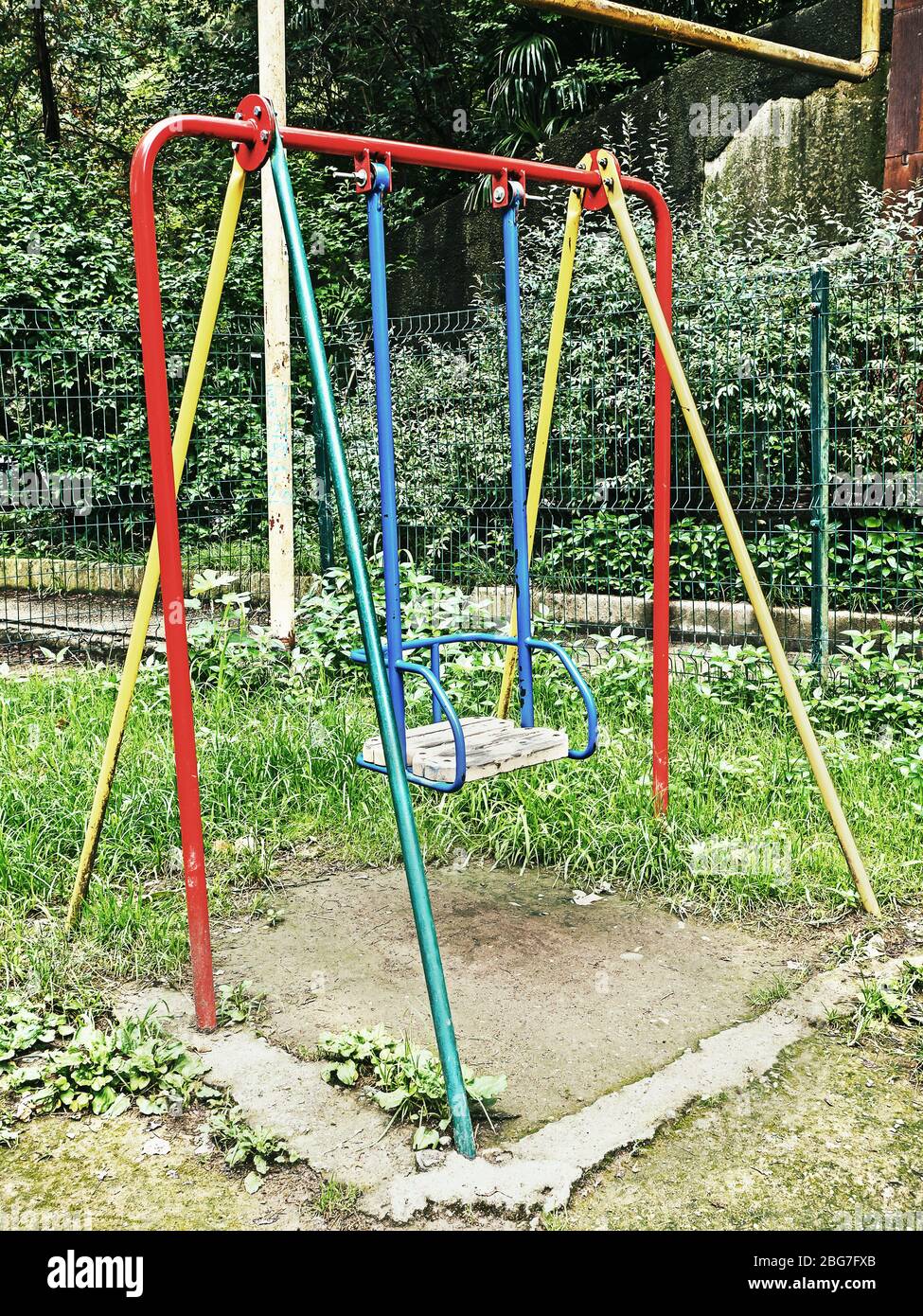 Children's colored swing in the playground on street Stock Photo - Alamy