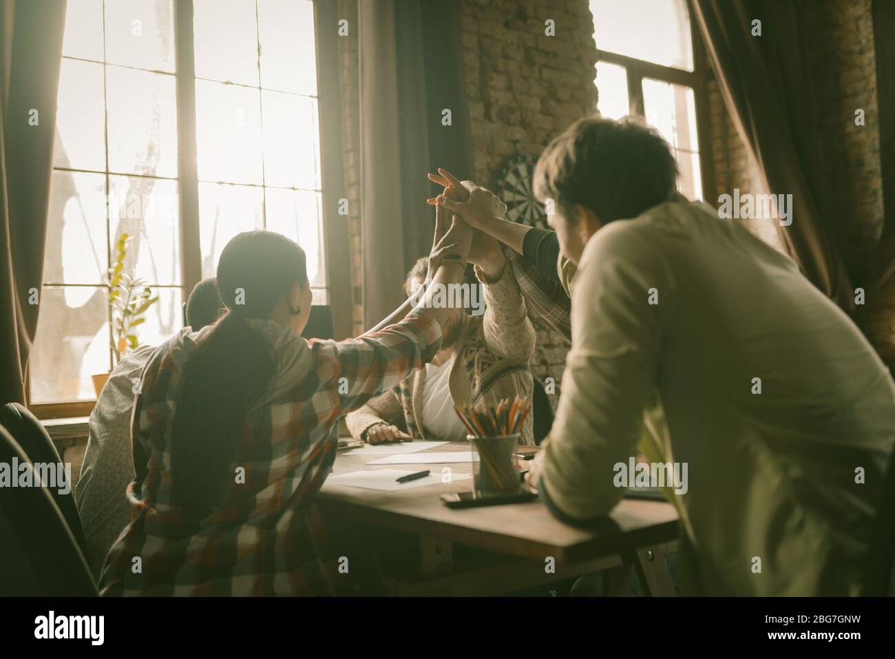Friendly Team Joining Their Hands In High Five Gesture Stock Photo - Alamy