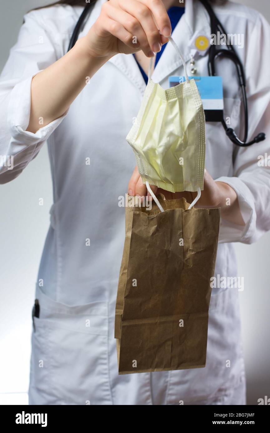 Female healthcare worker demonstrating bagging of mask for coronavirus ...